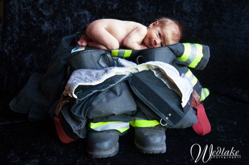 Newborn Baby Picture with Dad's Firefighter Gear - Wedlake Photographic